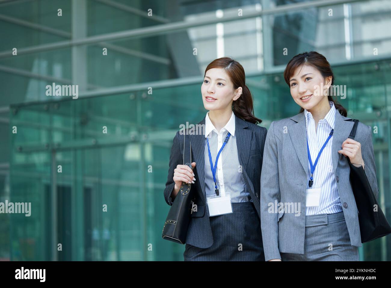 Two office workers walking through office building Stock Photo - Alamy