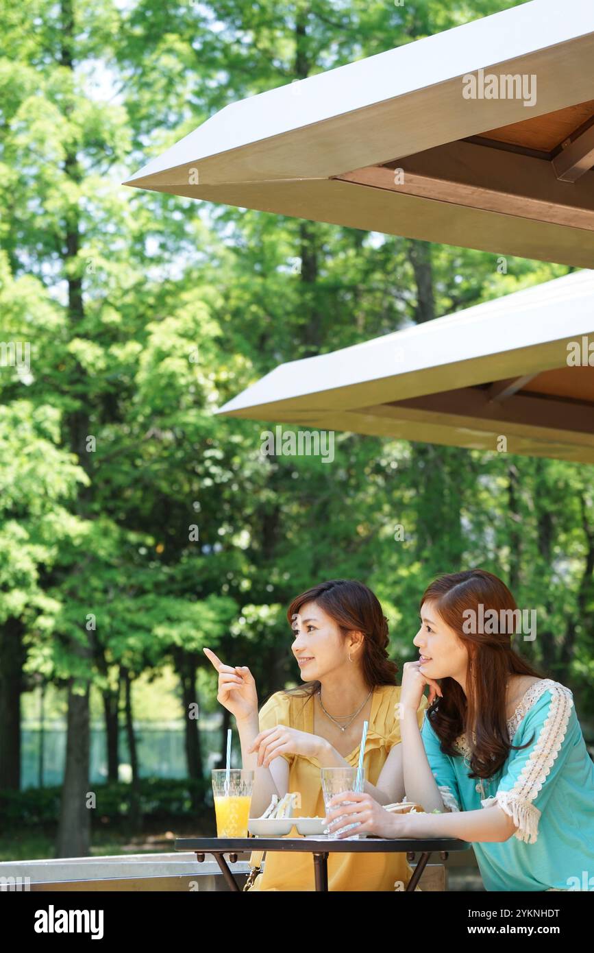 Two women having lunch at an open café Stock Photo - Alamy