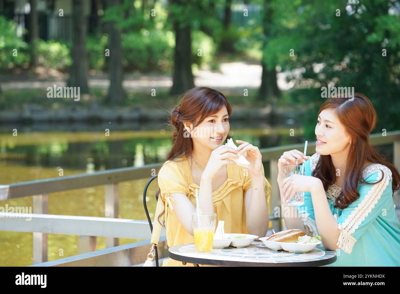 Two women having lunch at an open café Stock Photo - Alamy