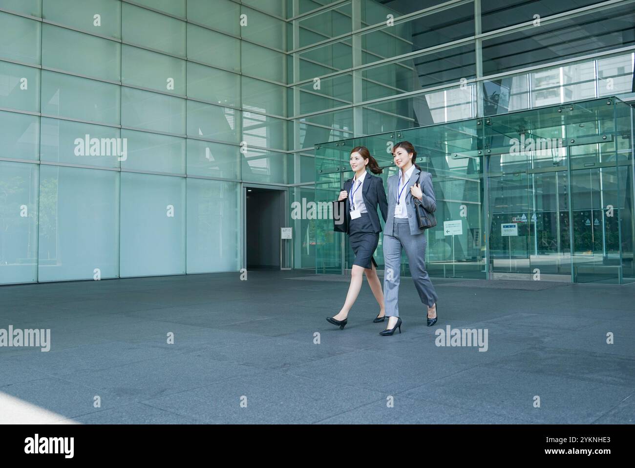 Two office workers walking through office building Stock Photo - Alamy