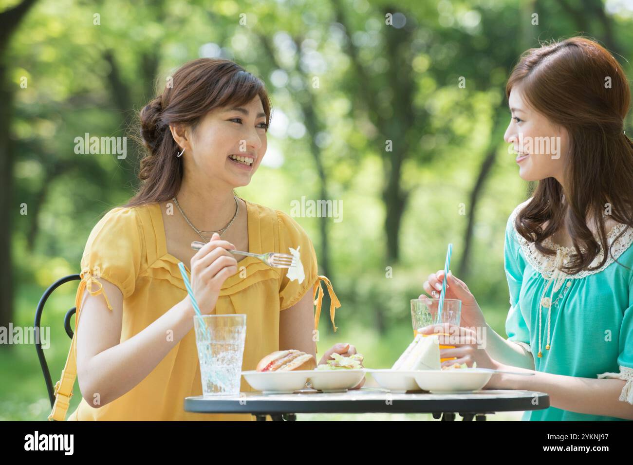 Two women having lunch at an open café Stock Photo - Alamy