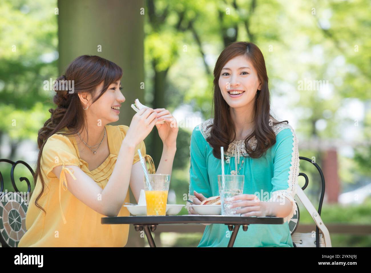 Two women having lunch at an open café Stock Photo - Alamy