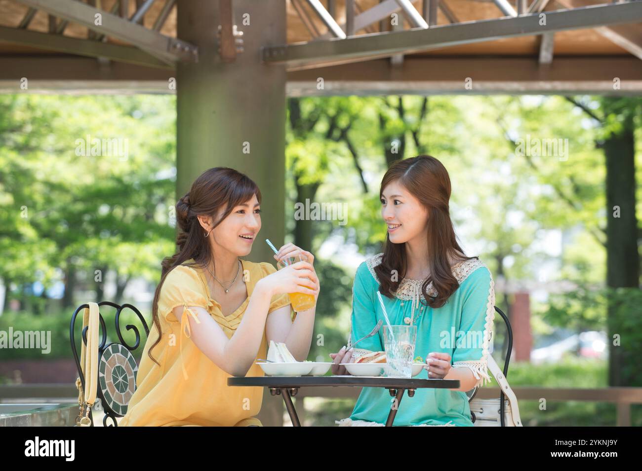 Two women having lunch at an open café Stock Photo - Alamy