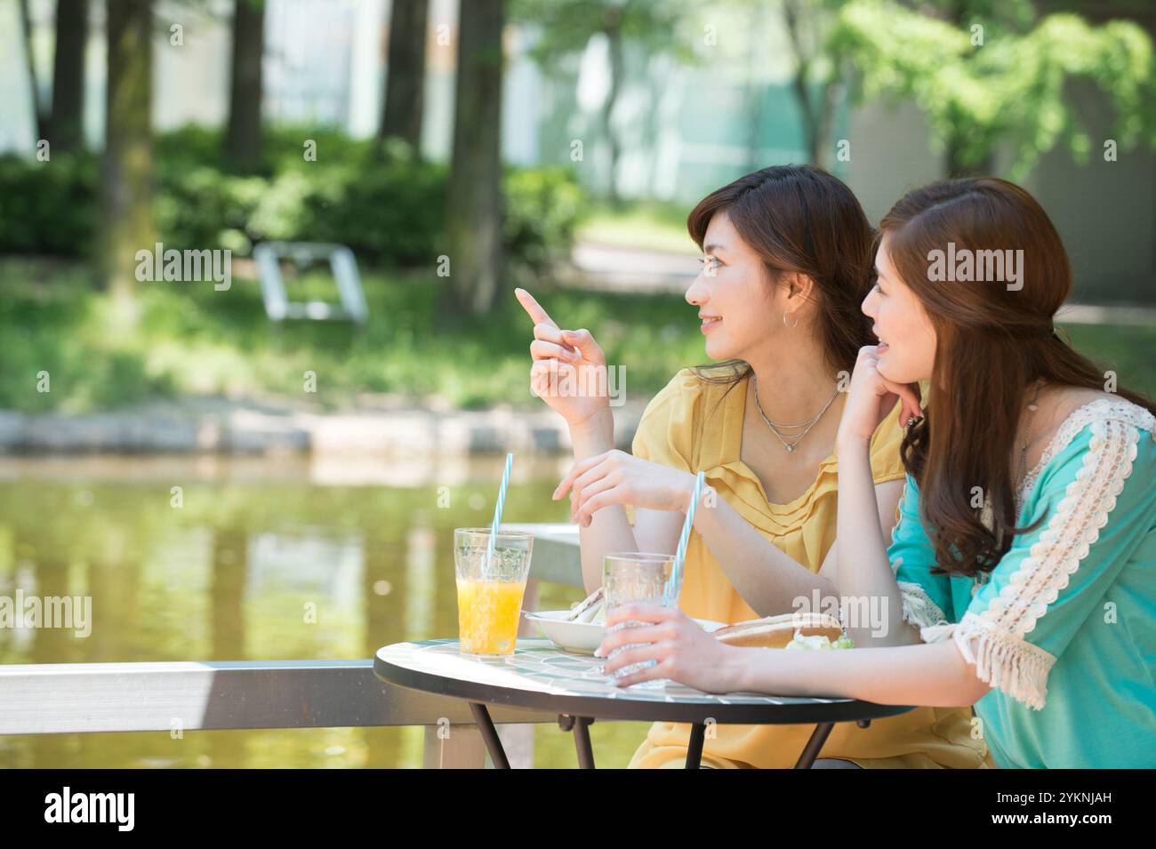Two women having lunch at an open café Stock Photo - Alamy
