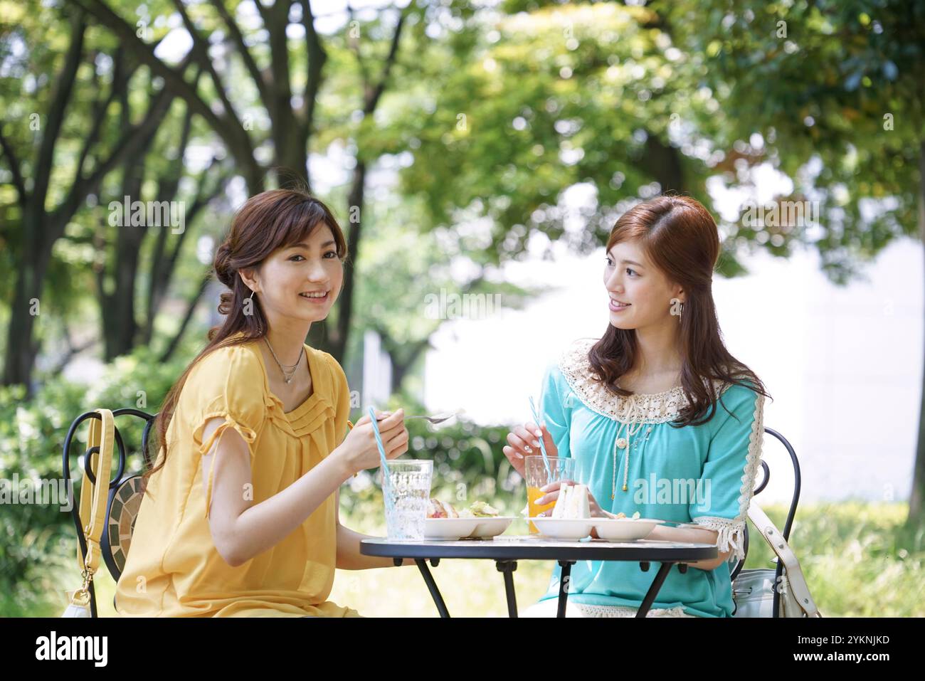 Two women having lunch at an open café Stock Photo - Alamy
