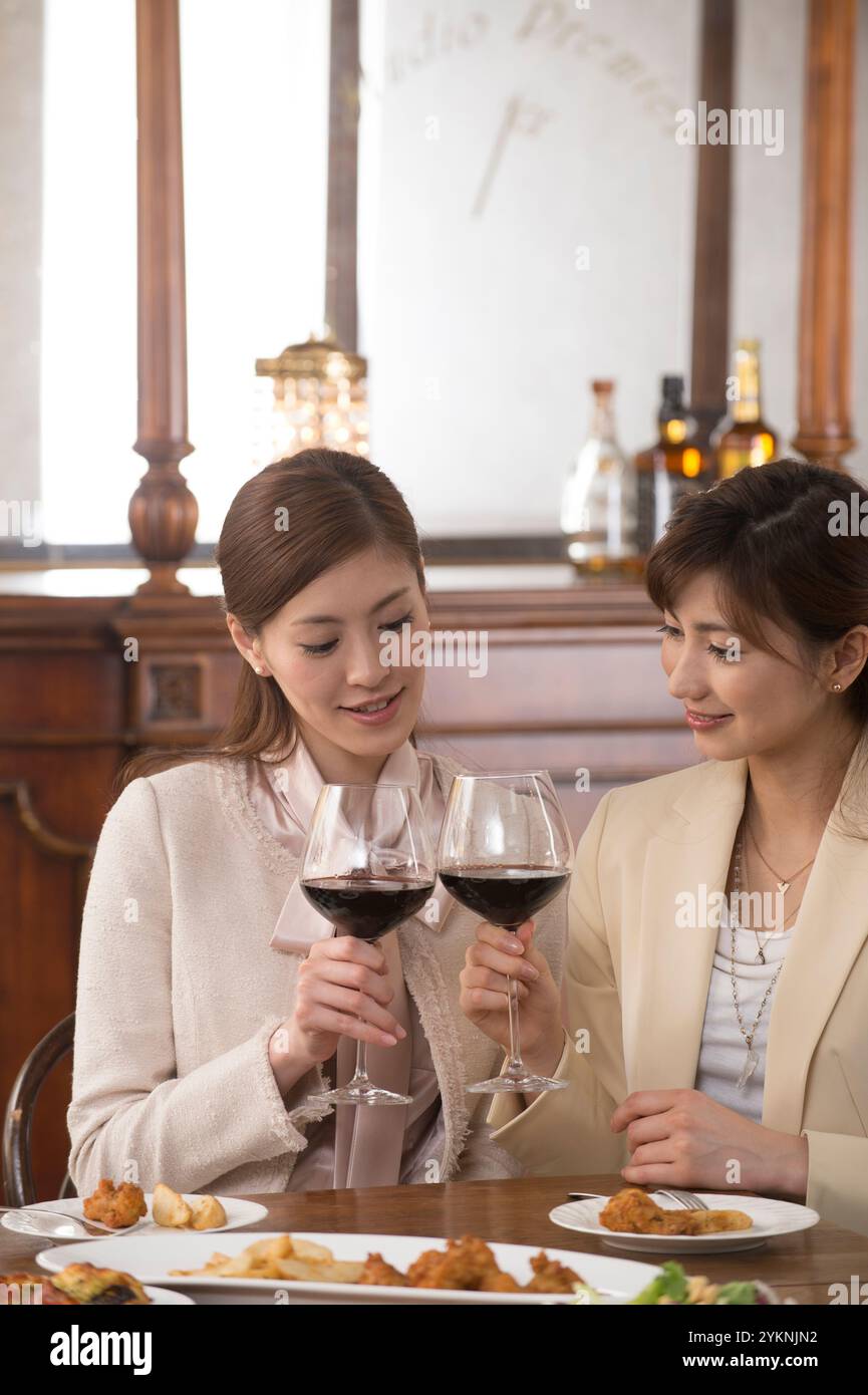 Two women toasting with red wine in a restaurant Stock Photo - Alamy
