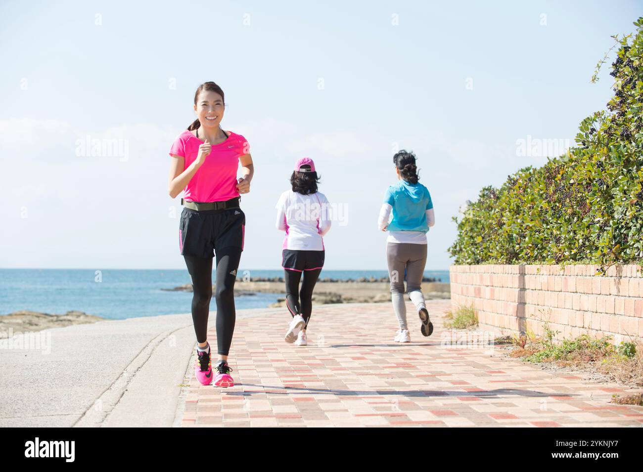 Three women running on the beach Stock Photo - Alamy