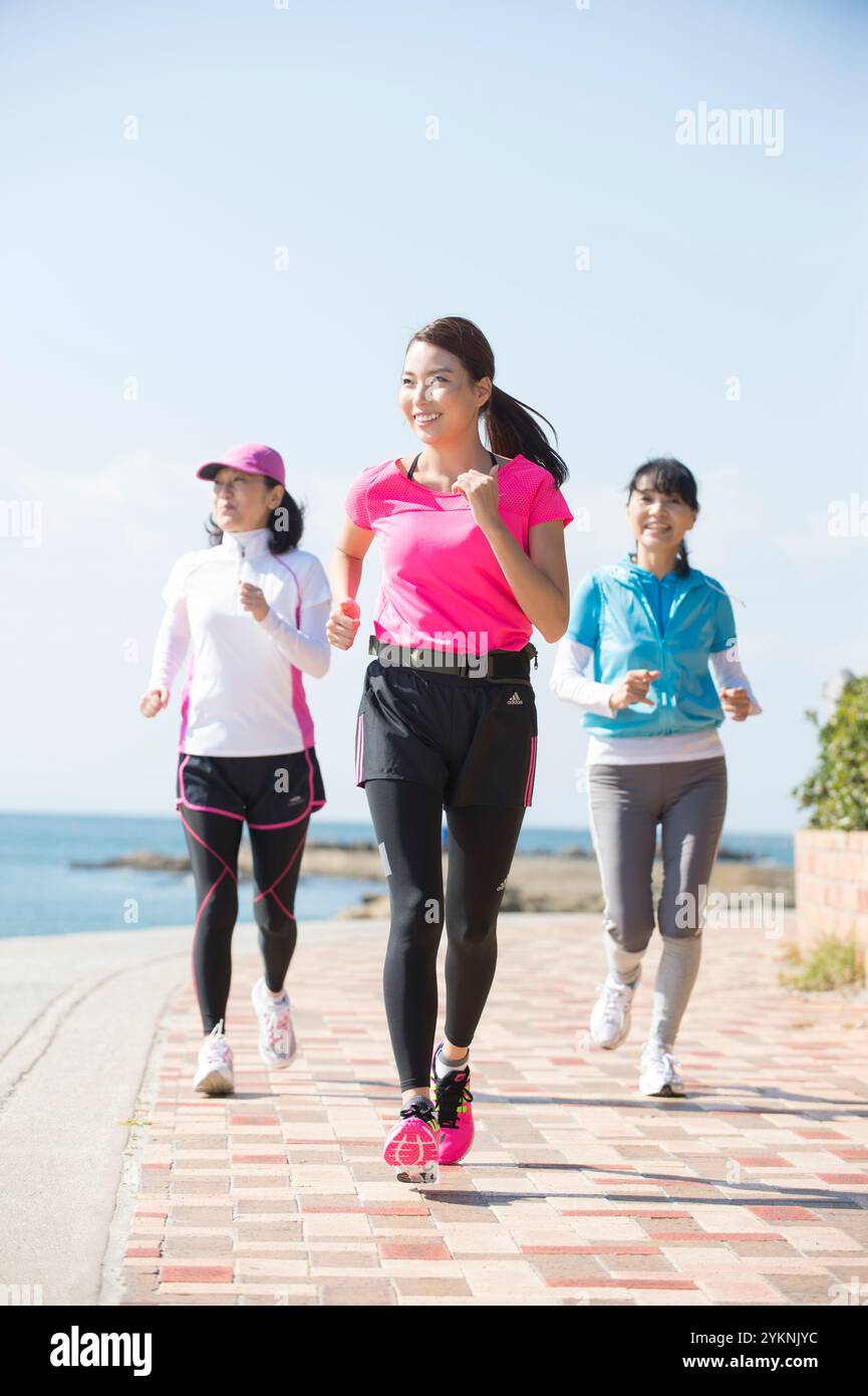 Three women running on the beach Stock Photo - Alamy