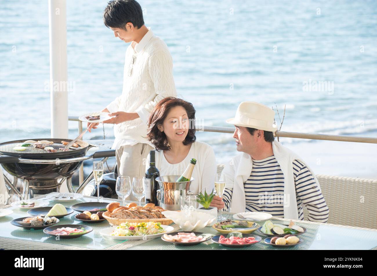 Family barbecuing at a restaurant on the beach Stock Photo - Alamy