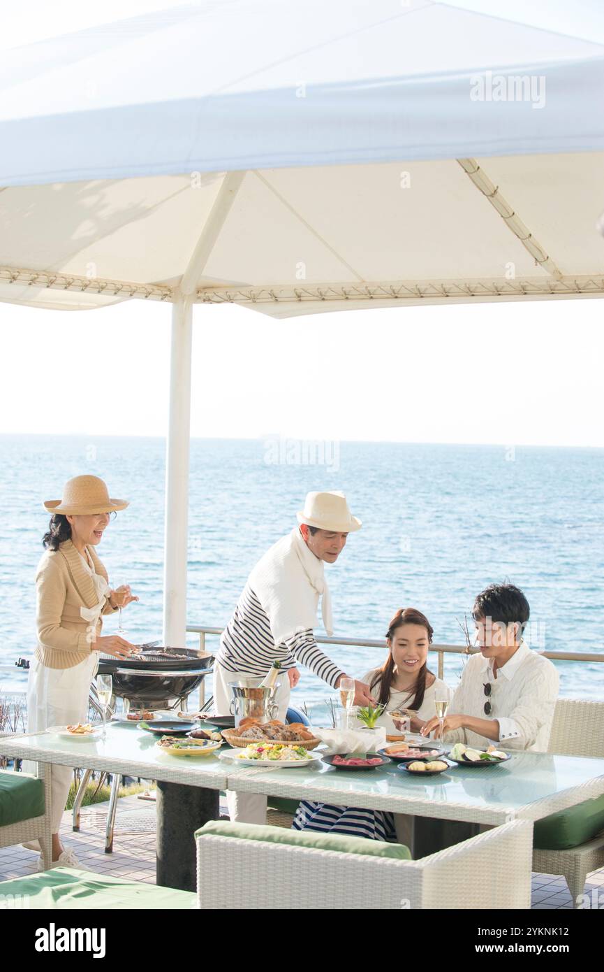 Family barbecuing at a restaurant on the beach Stock Photo - Alamy