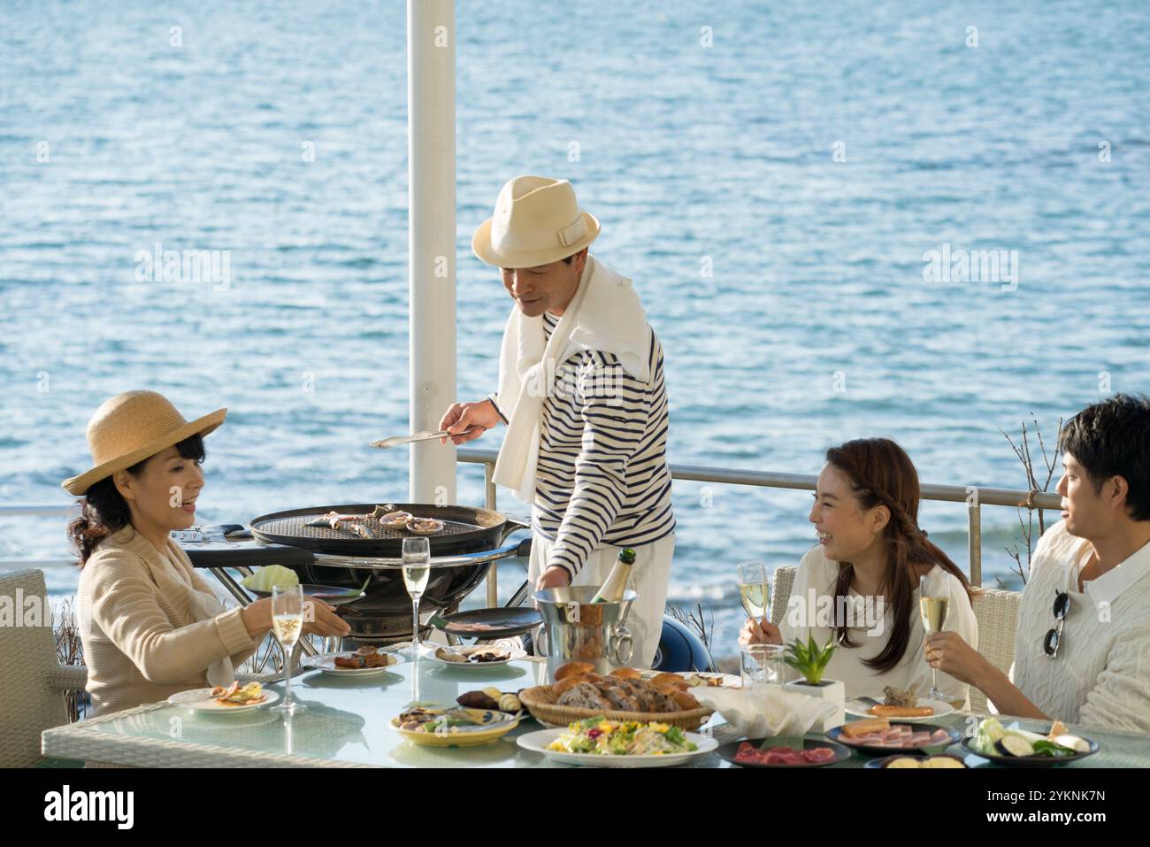 Family barbecuing at a restaurant on the beach Stock Photo - Alamy
