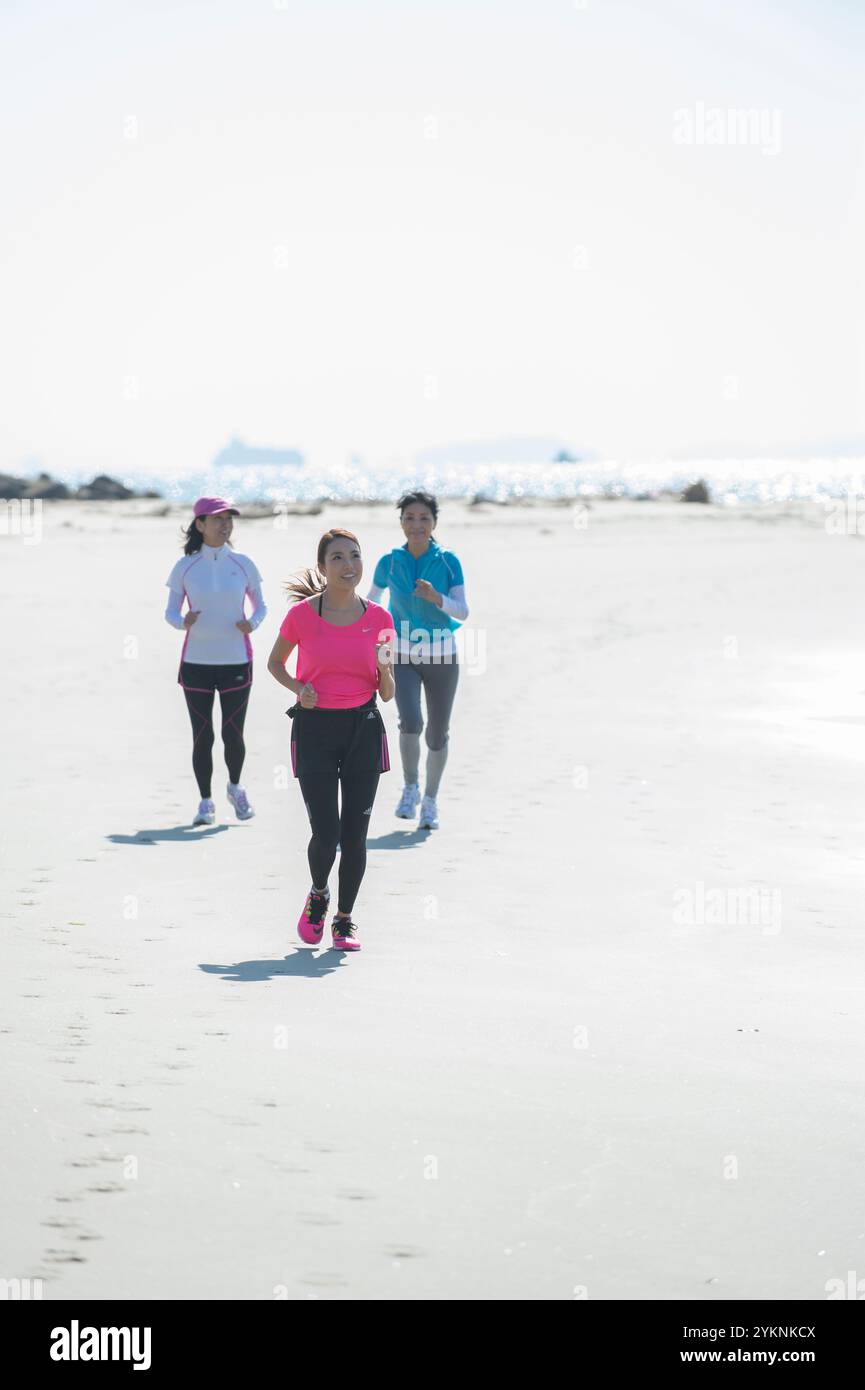 Three women running on the beach Stock Photo - Alamy