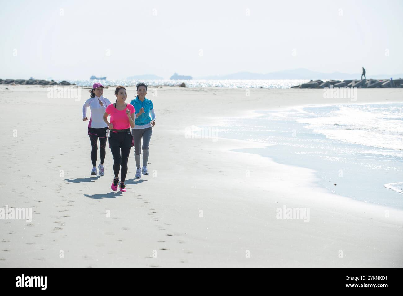 Three women running on the beach Stock Photo - Alamy