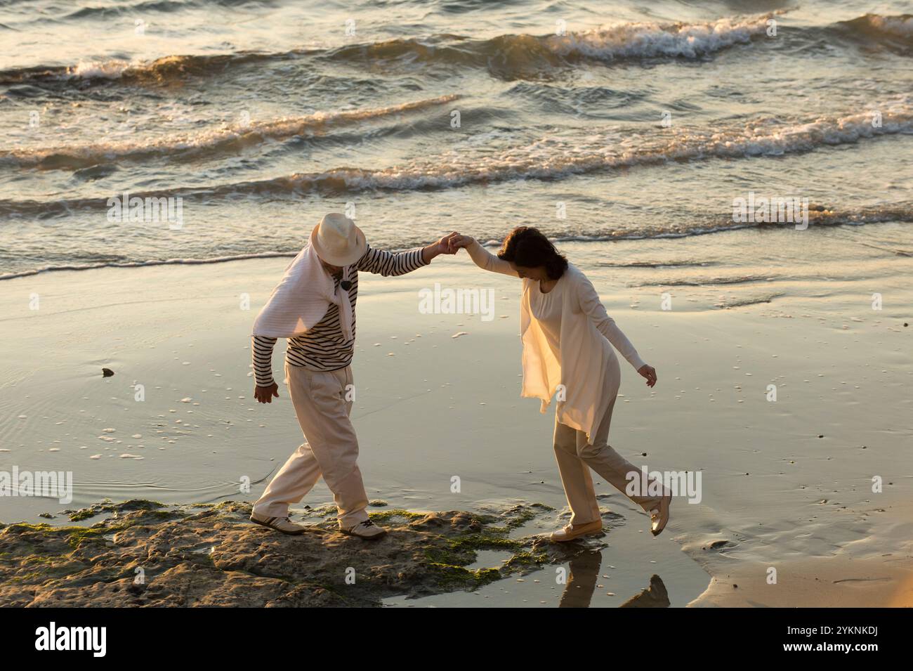Middle-aged couple strolling on the beach Stock Photo - Alamy
