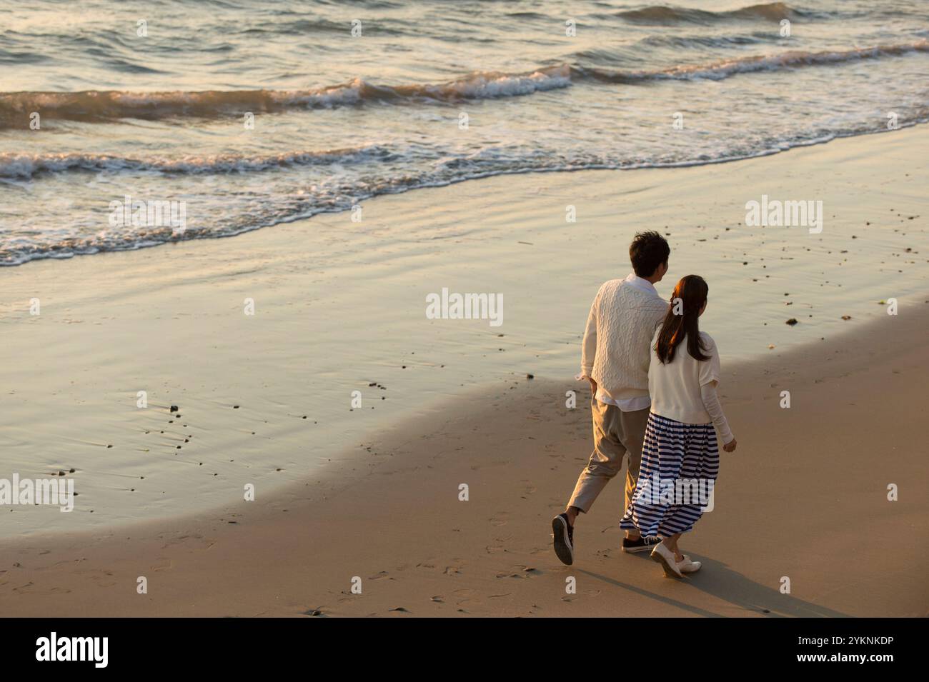 Couple taking a walk on the beach Stock Photo - Alamy