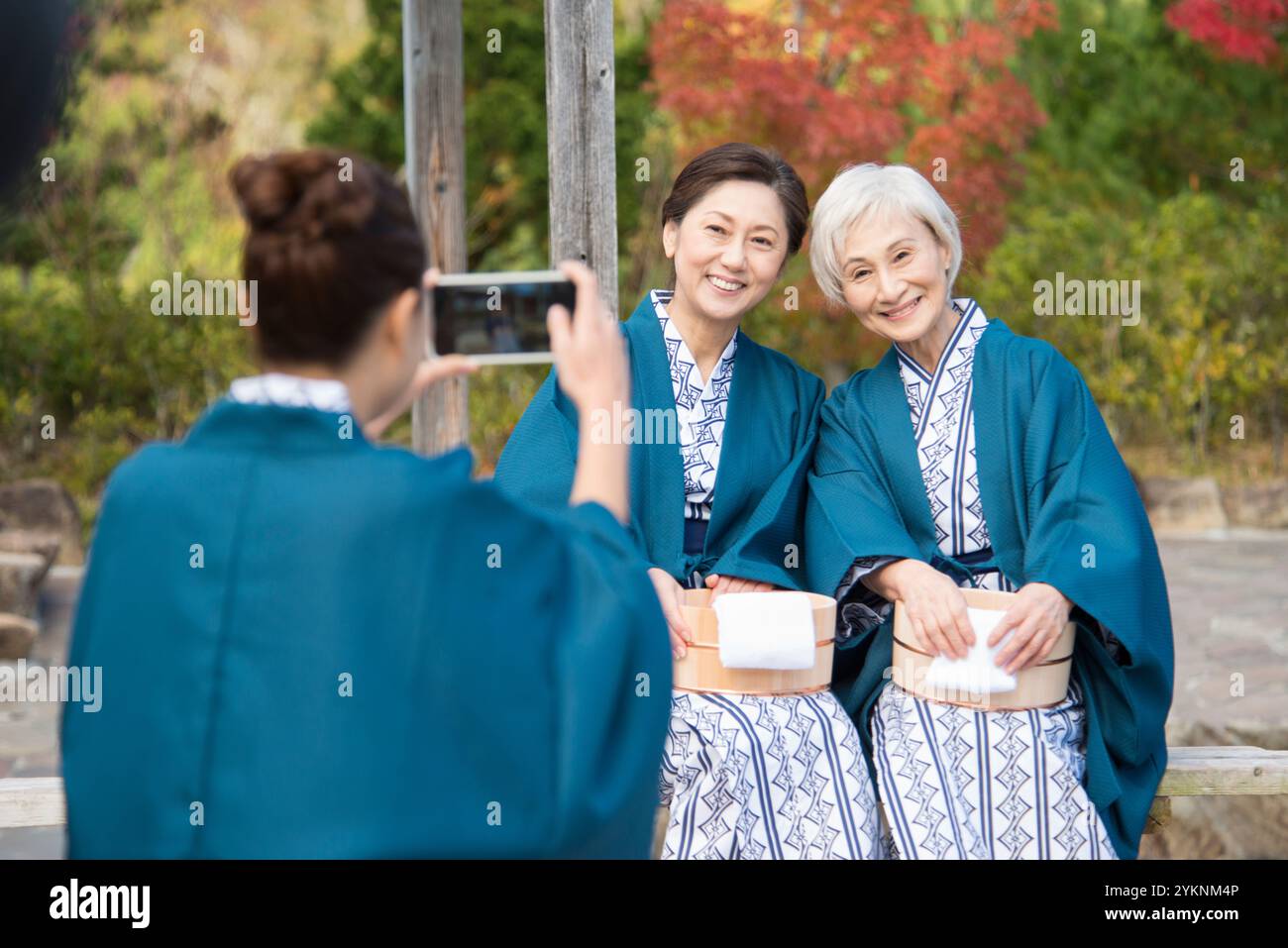 Three generations of parents and children in yukata taking photos at a ...