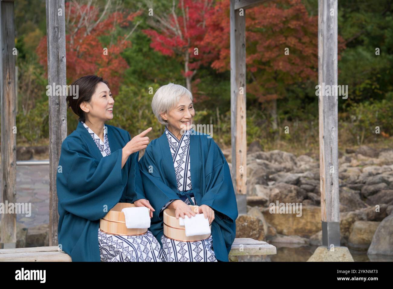 Woman in yukata holding a tub and hand towel at a hot spring ryokan in ...
