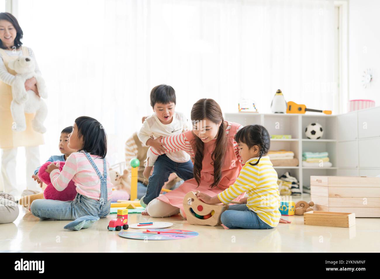 Children playing in a nursery school and nursery staff Stock Photo - Alamy