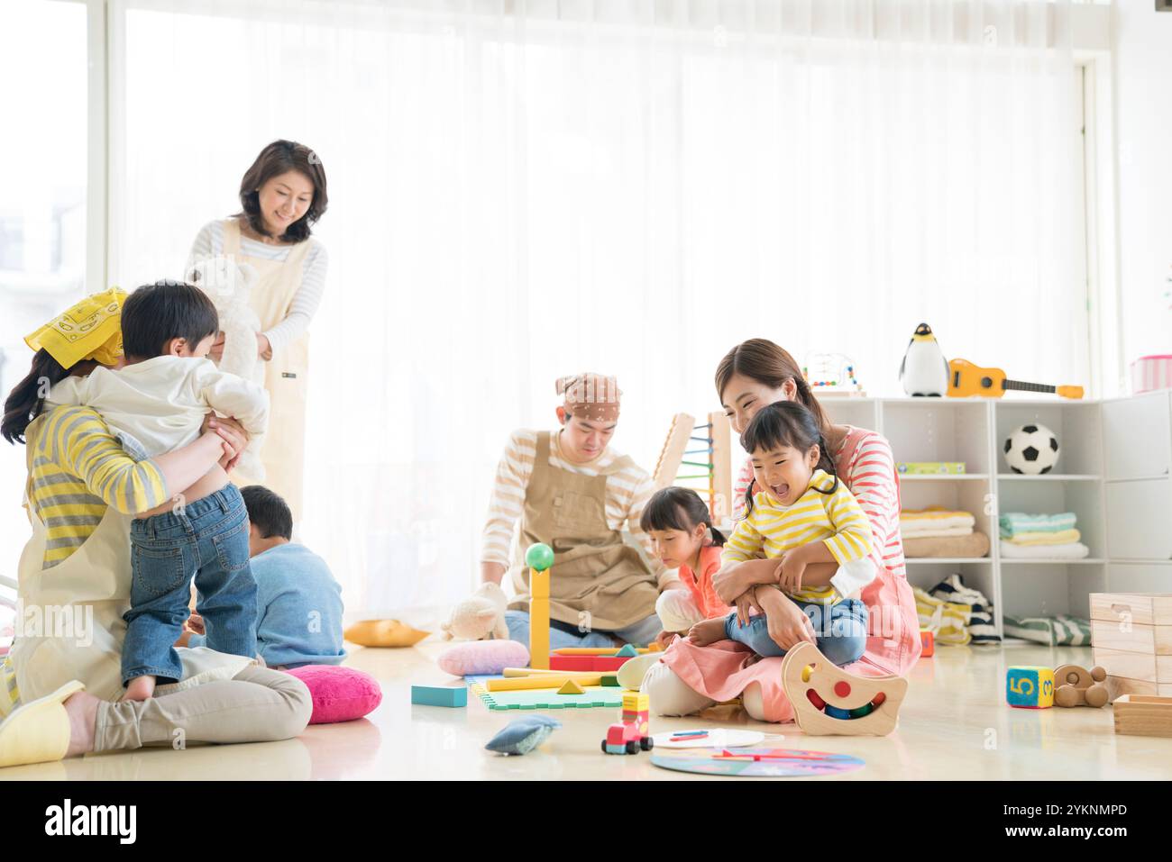 Children playing in a nursery school and nursery staff Stock Photo - Alamy