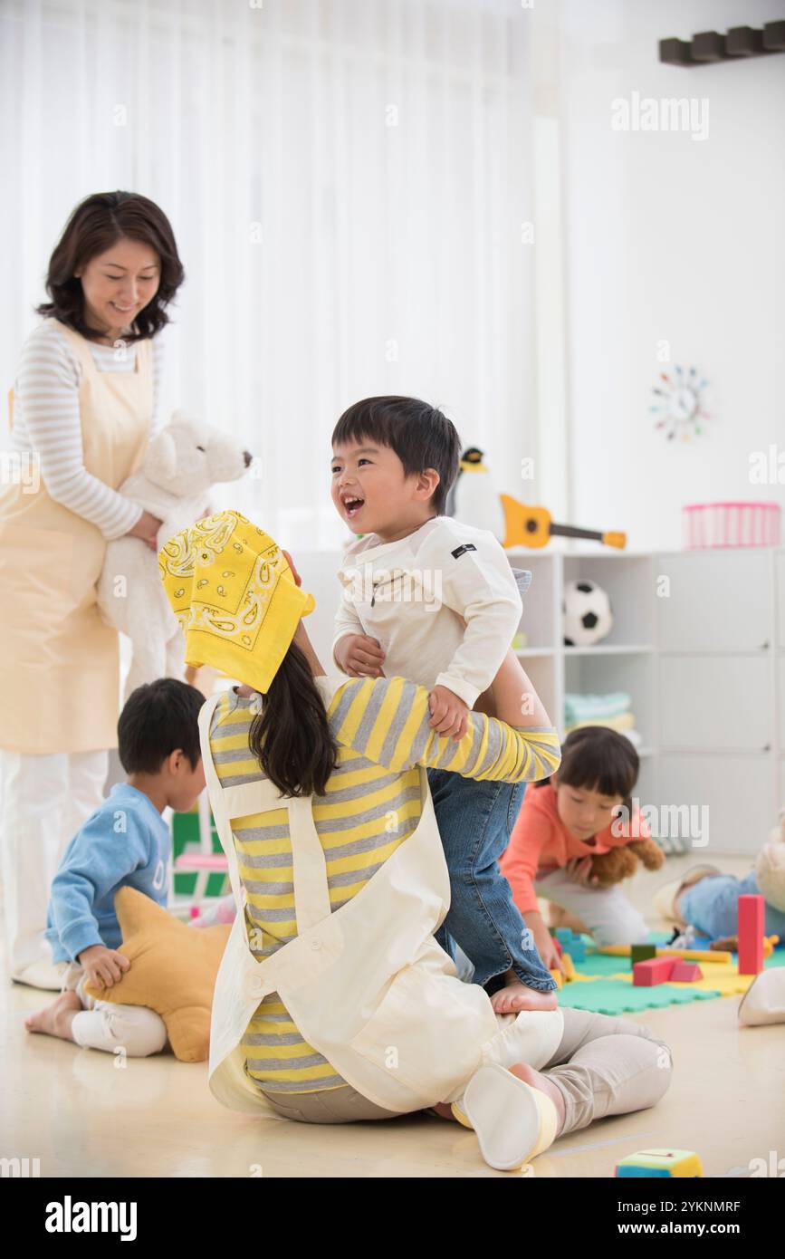 Children playing in a nursery school and nursery staff Stock Photo - Alamy