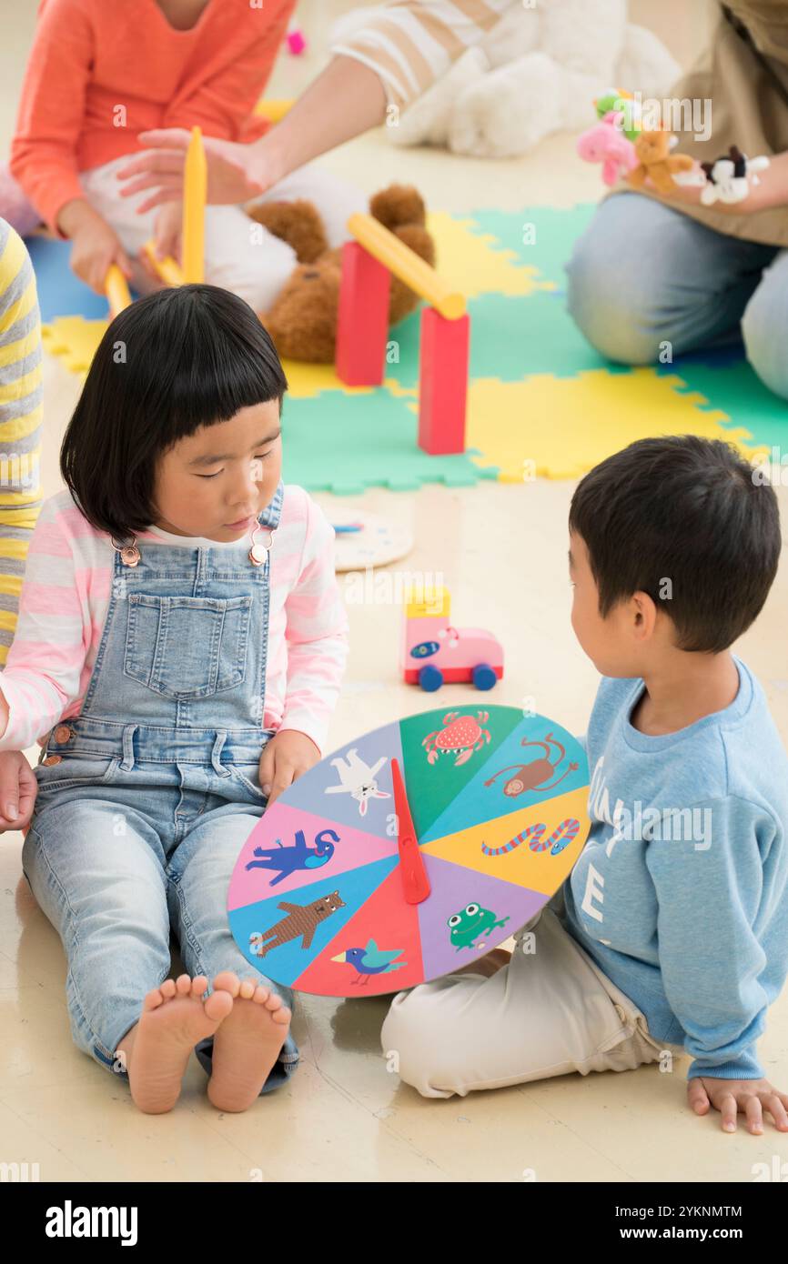 Children playing in a nursery school and nursery staff Stock Photo - Alamy