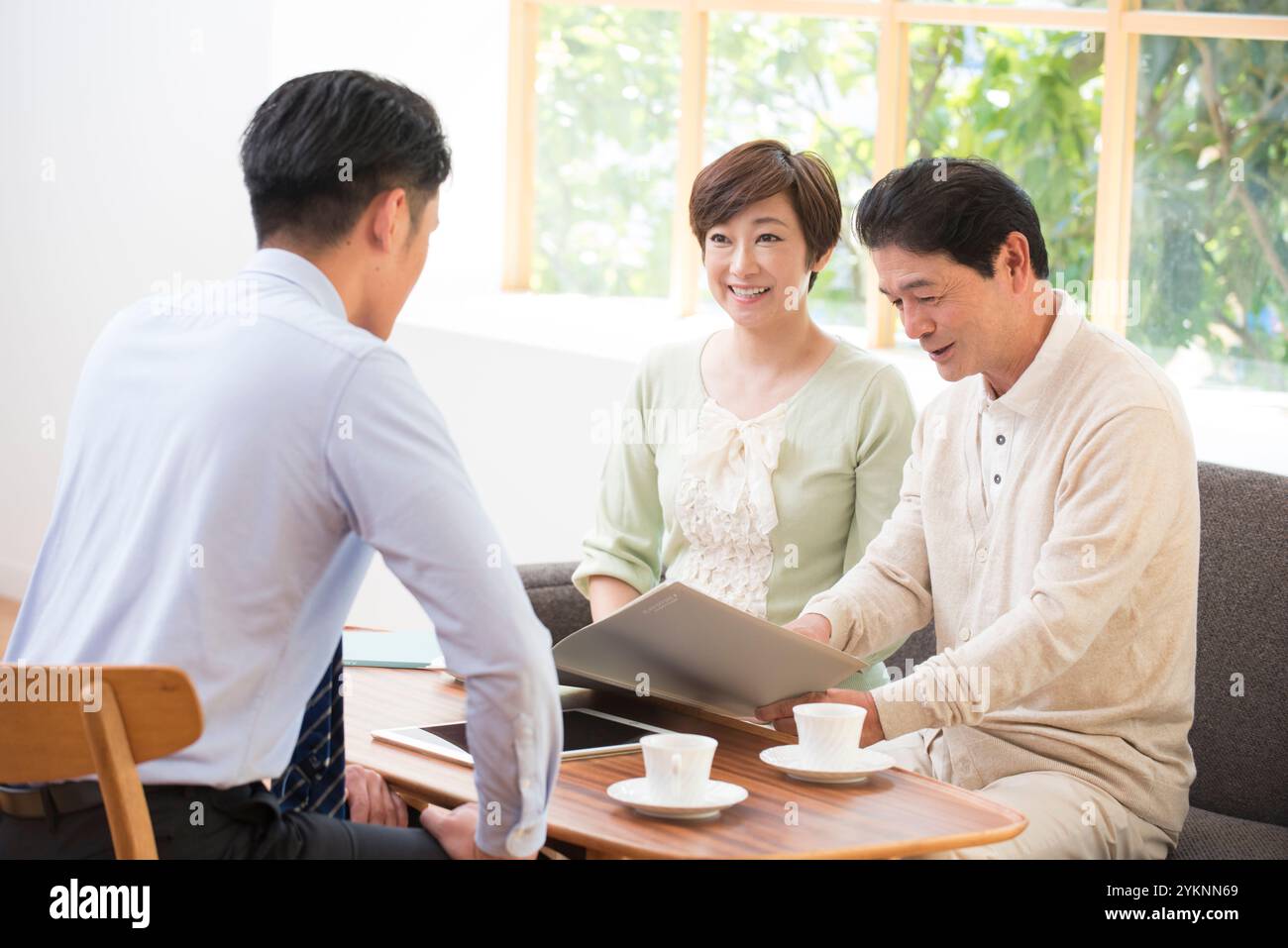 Middle-aged couple receiving explanation from salesman Stock Photo - Alamy