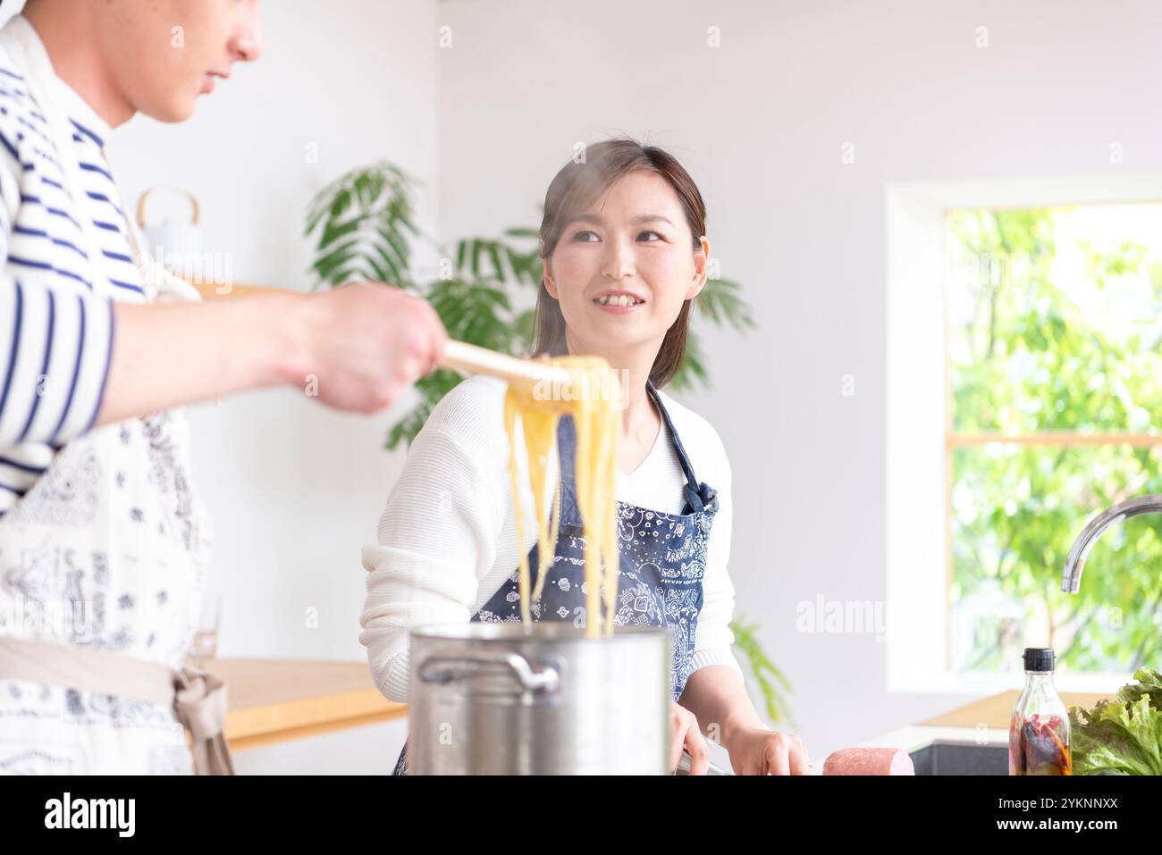 Couple in their 30s cooking in kitchen Stock Photo - Alamy