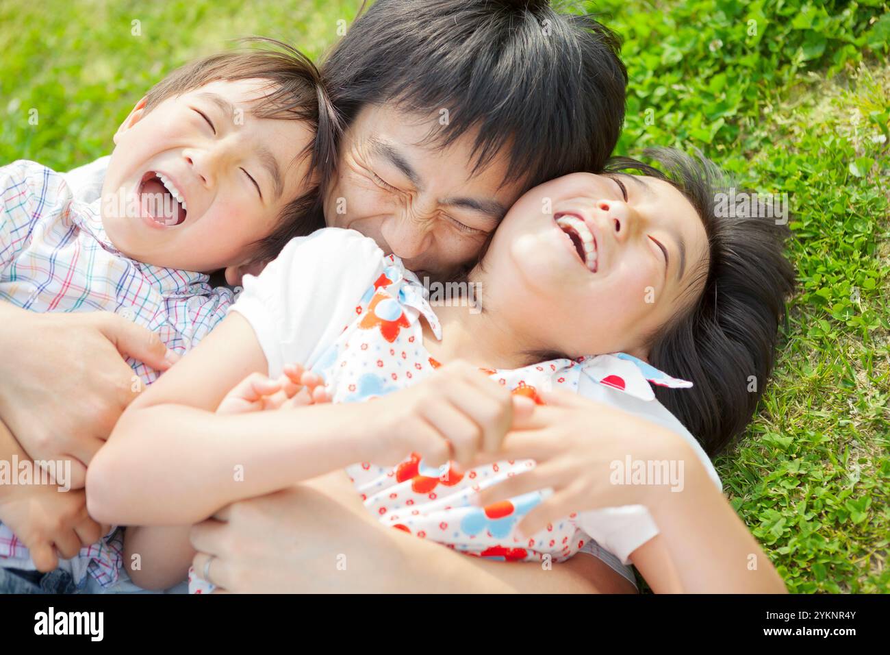 Parent and child lying down and hugging Stock Photo - Alamy
