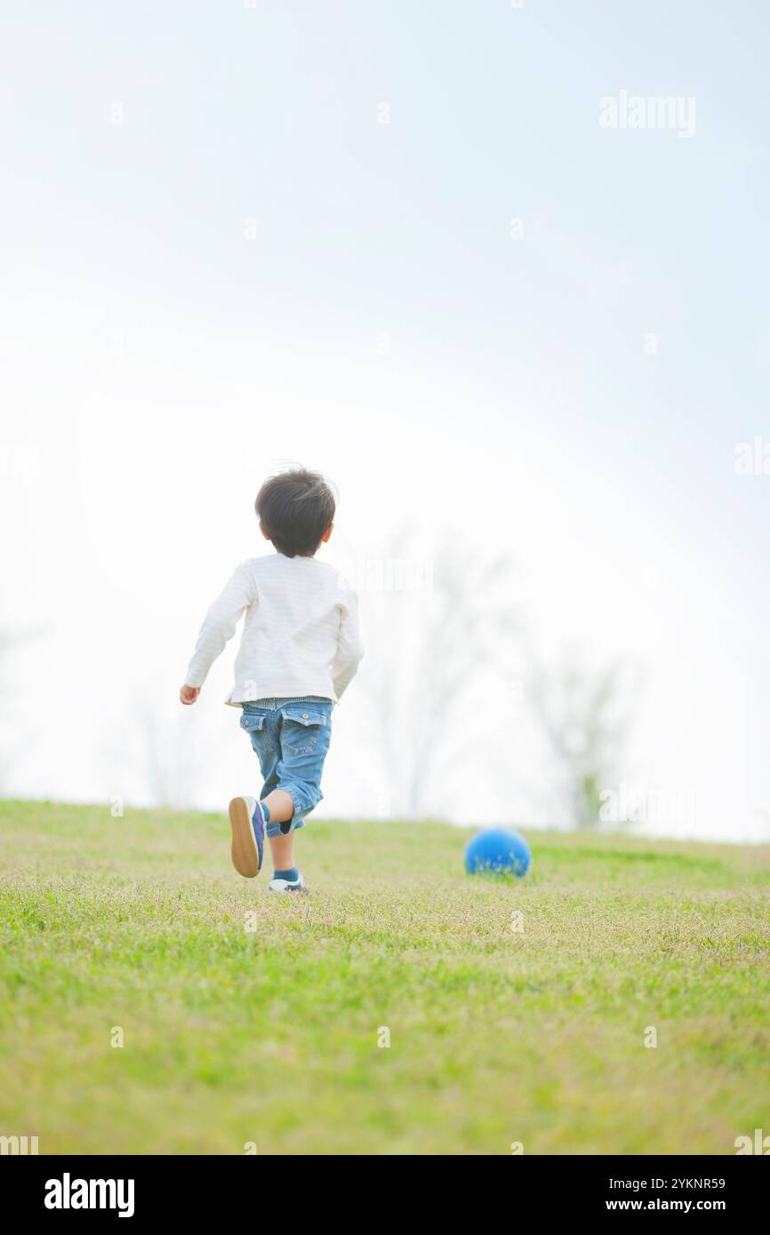 Boy chasing ball Stock Photo - Alamy