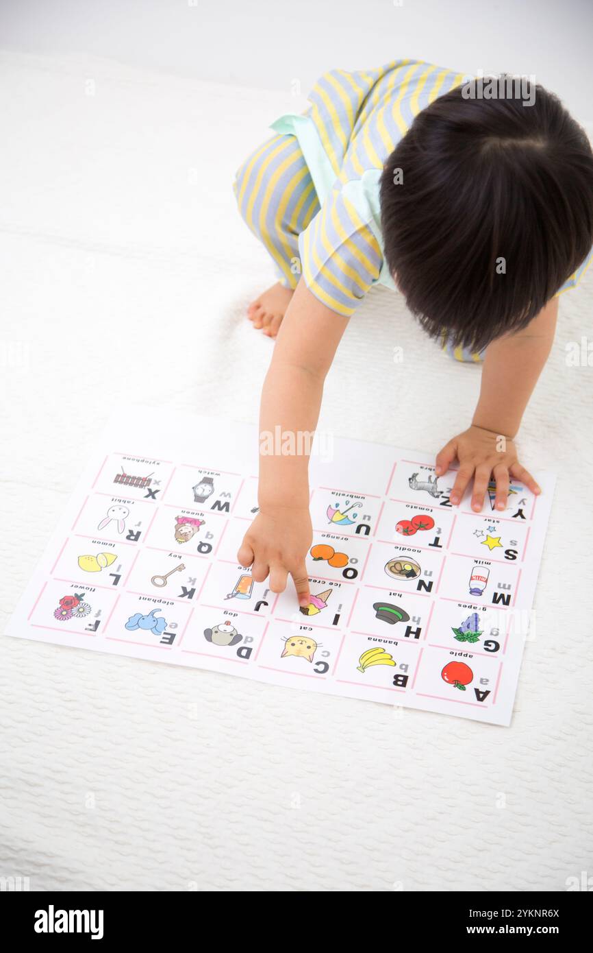 Boy pointing to the alphabet table Stock Photo - Alamy