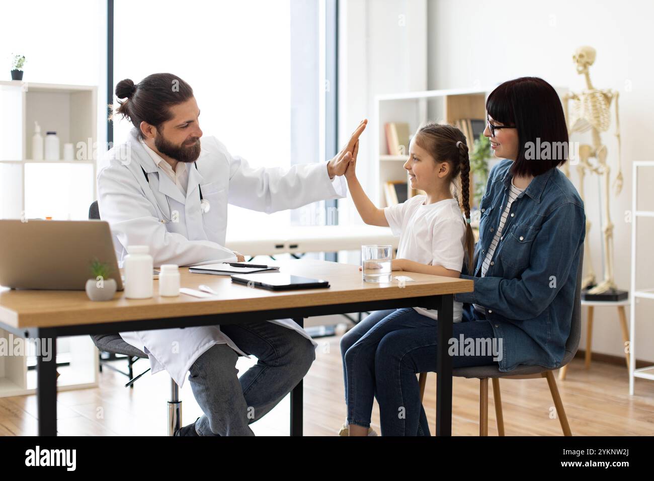 Friendly doctor giving high five to young girl in clinic setting Stock ...