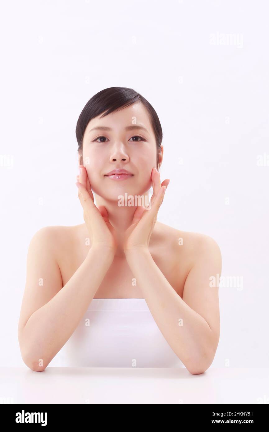 Woman with hand on cheek taking care of skin Stock Photo - Alamy