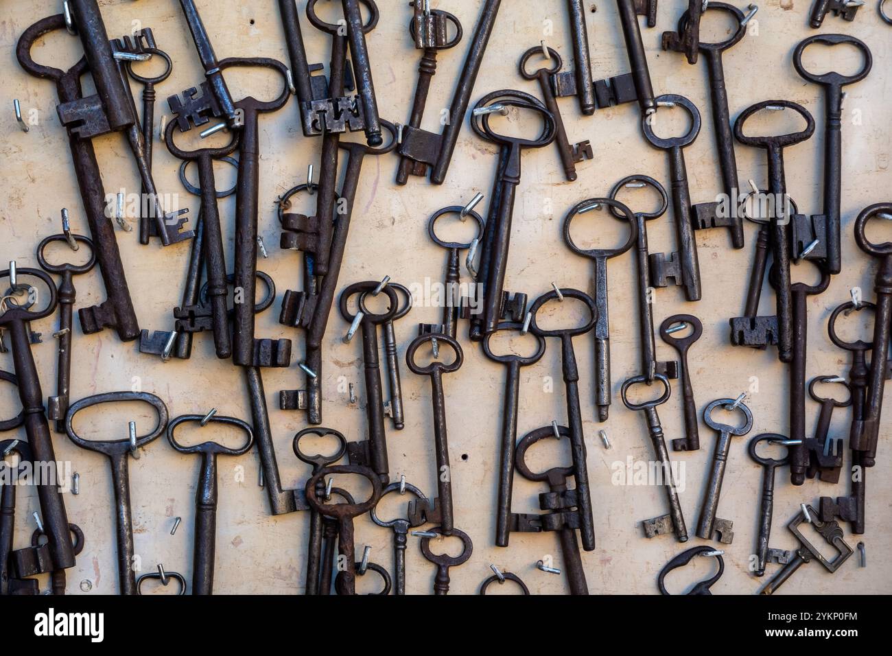 Scattered vintage iron keys on rustic surface showcasing ancient design ...
