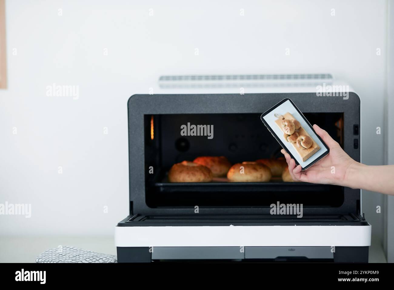 Women's hands, microwave and smartphone Stock Photo - Alamy