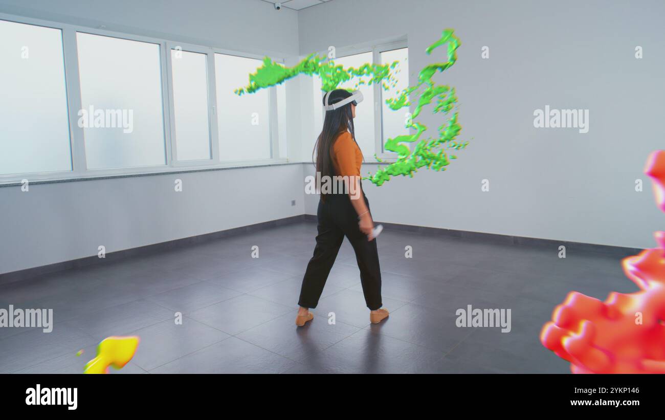 Creative Asian female artist in augmented reality headset paints with ...