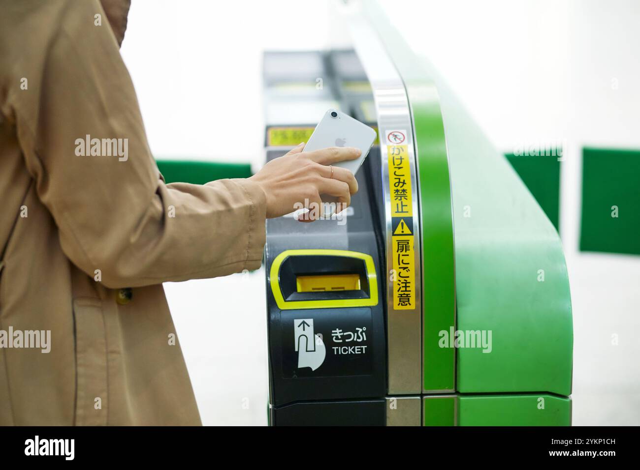 Woman's hand through ticket gate Stock Photo - Alamy