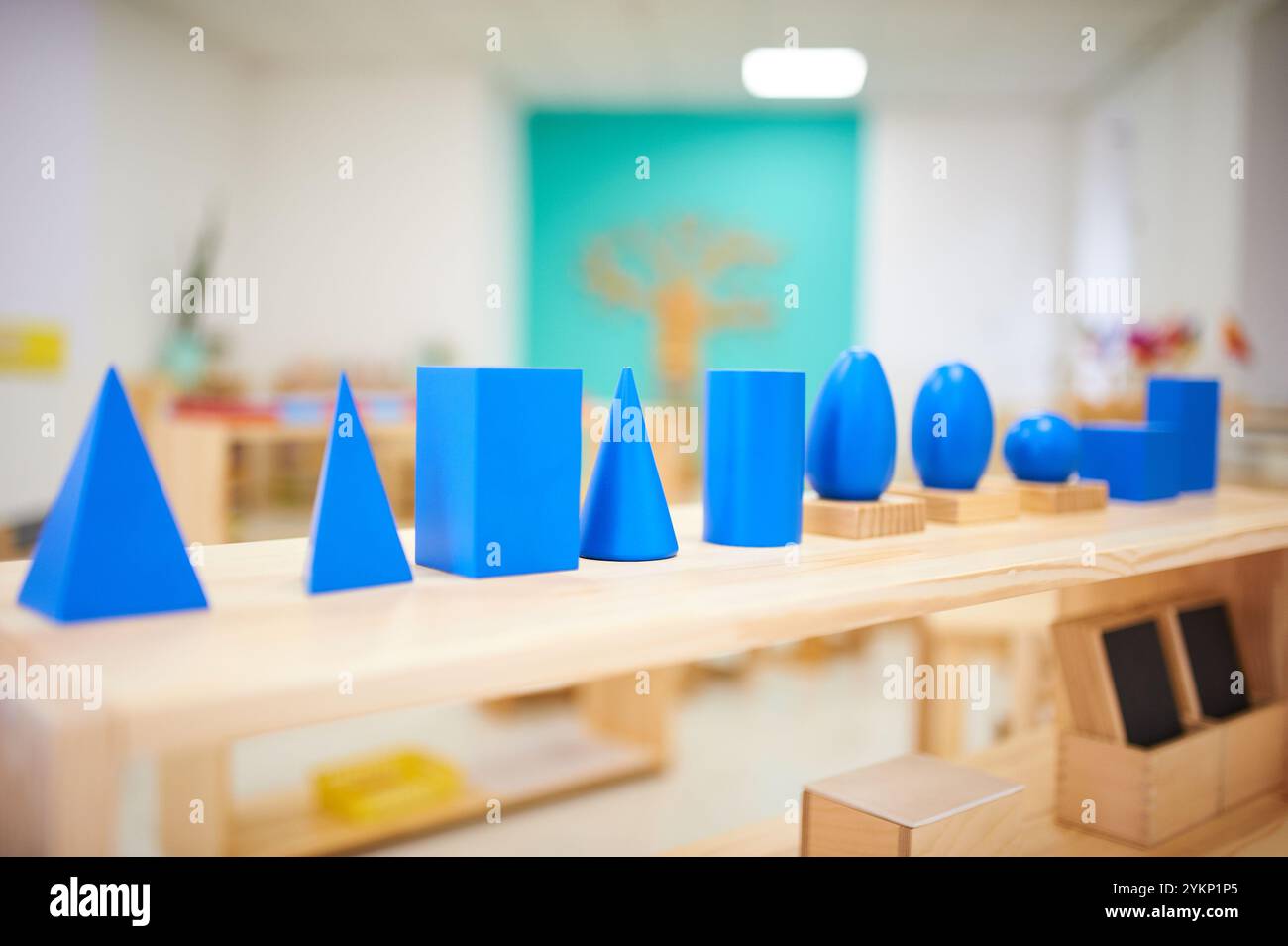 Montessori geometric solids in a preschool classroom. Bright blue ...