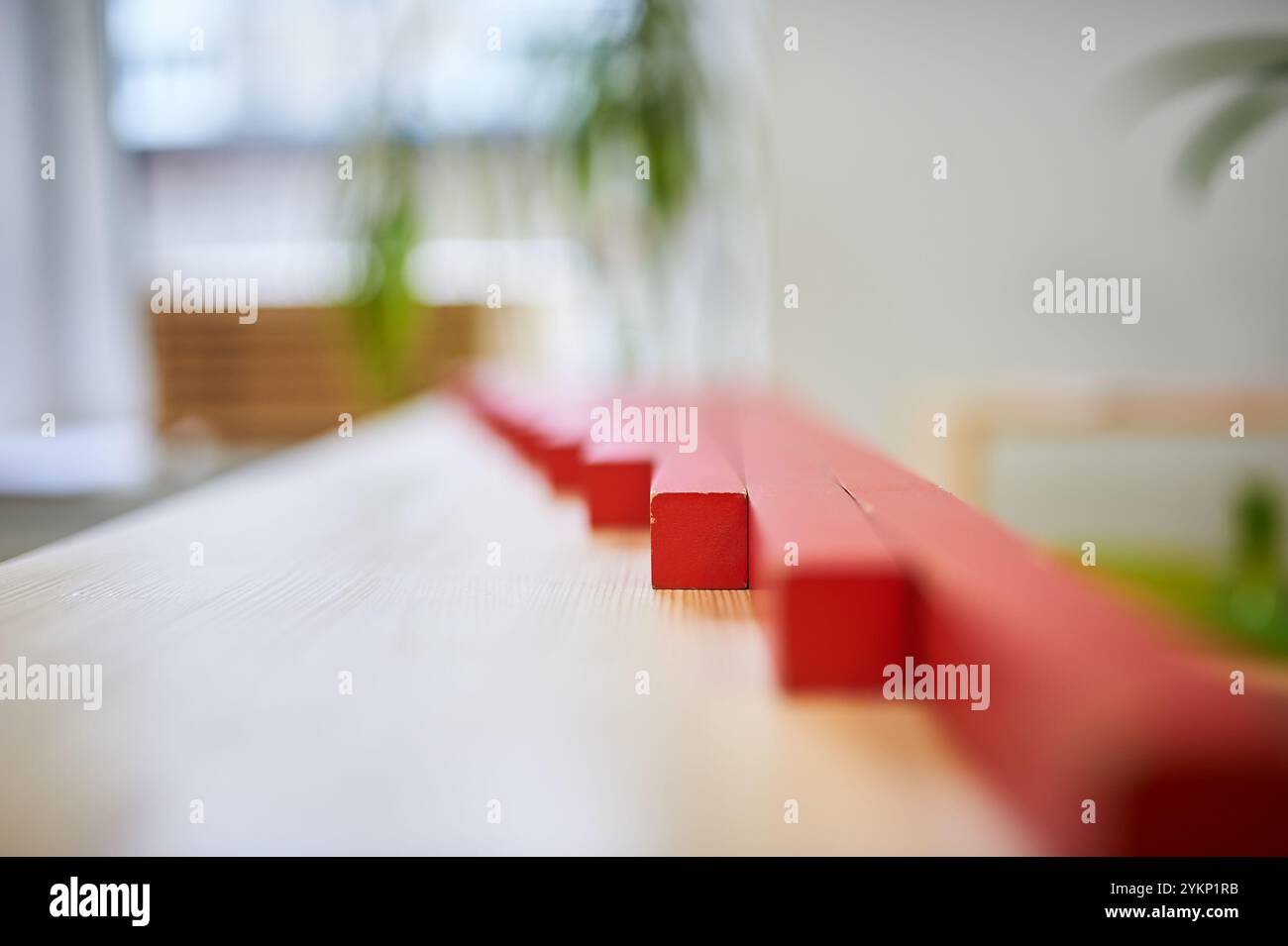 Montessori red rods arranged in descending order of length on a wooden ...