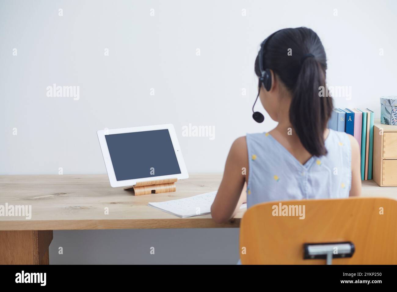 A primary school girl with an intercom studying on a tablet PC Stock ...