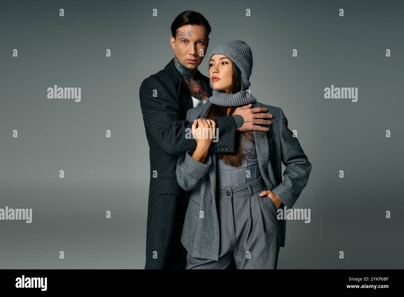 A fashionable young couple showcases modern gray attire and striking ...
