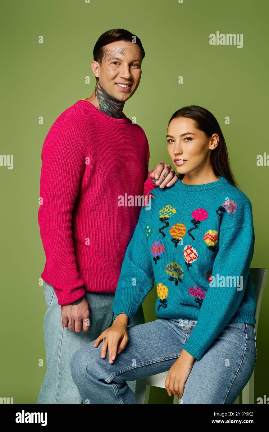A stylish young couple poses casually in trendy sweaters for a portrait ...