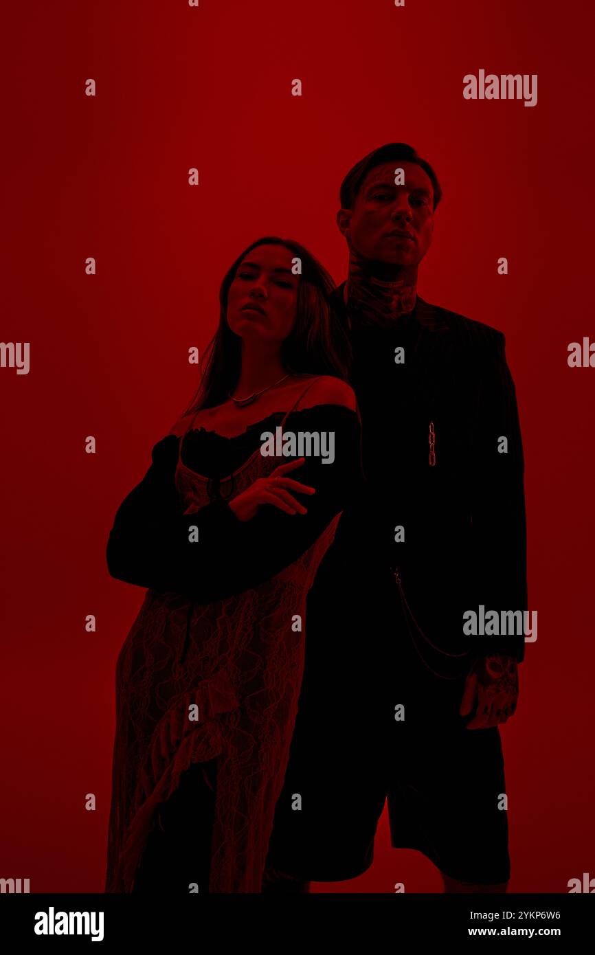 A stylish young couple stands together, exuding confidence in a vivid ...