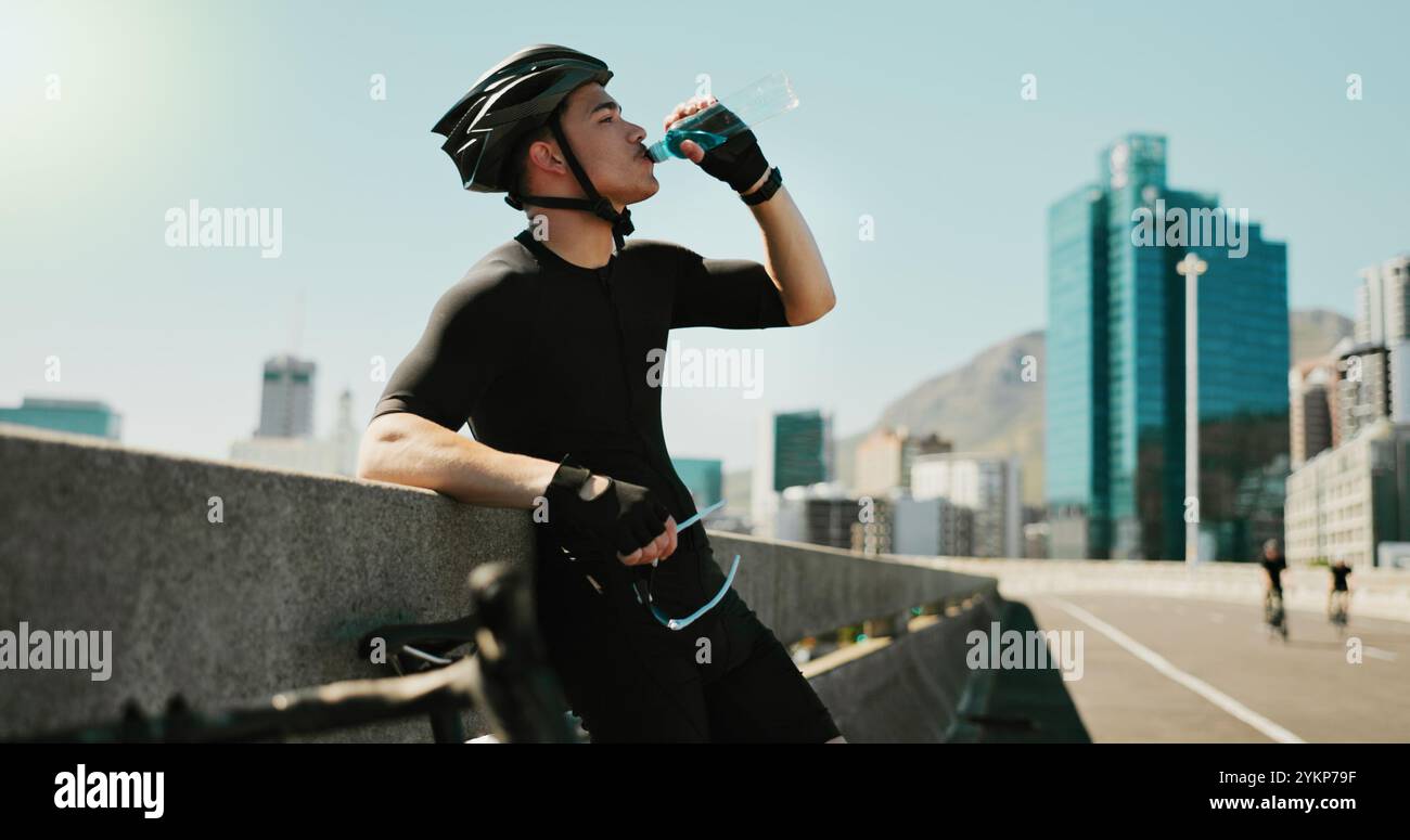 Drinking water, training and cycling with man in city for triathlon ...
