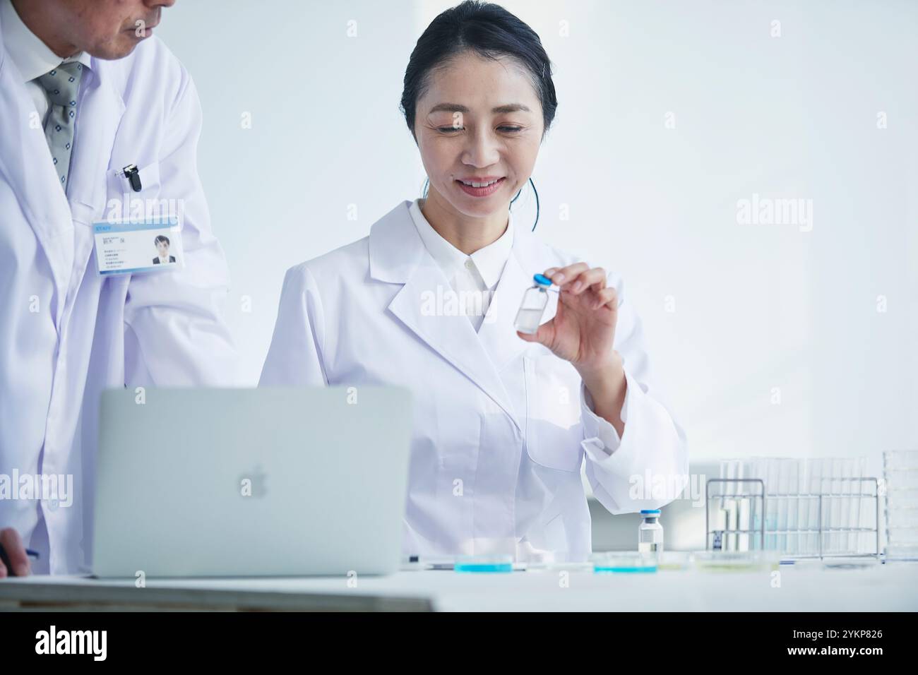 Female and male researchers in white coats doing research Stock Photo ...
