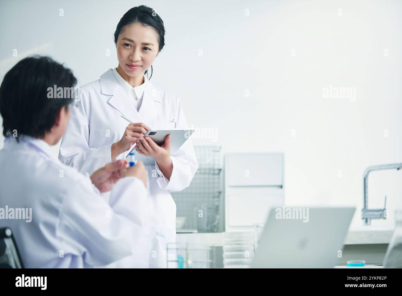Female and male researchers in white coats doing research Stock Photo ...