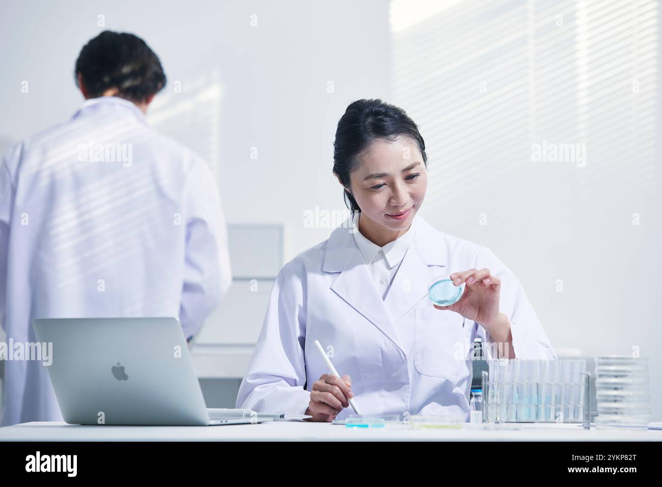 Female and male researchers in white coats doing research Stock Photo ...