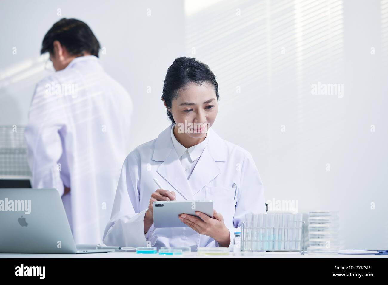 Female and male researchers in white coats doing research Stock Photo ...