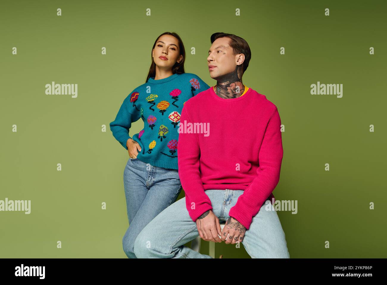 Two attractive individuals confidently pose in colorful sweaters ...