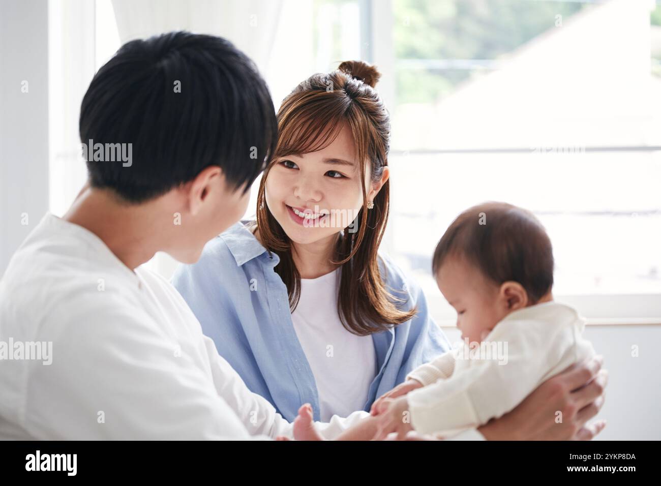 Three parents and their children relaxing in the living room Stock ...