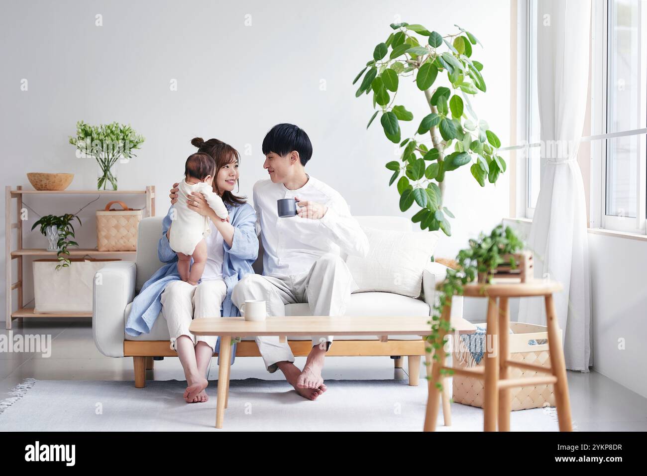 Three parents and their children relaxing in the living room Stock ...